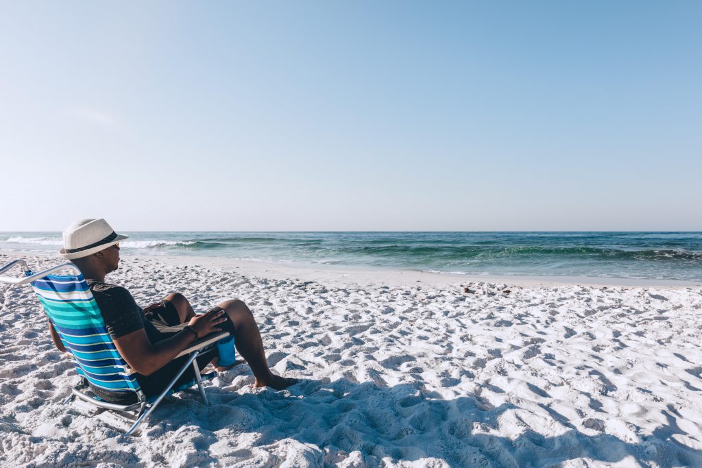 Black man relaxing on the beach - Creative Flame Media